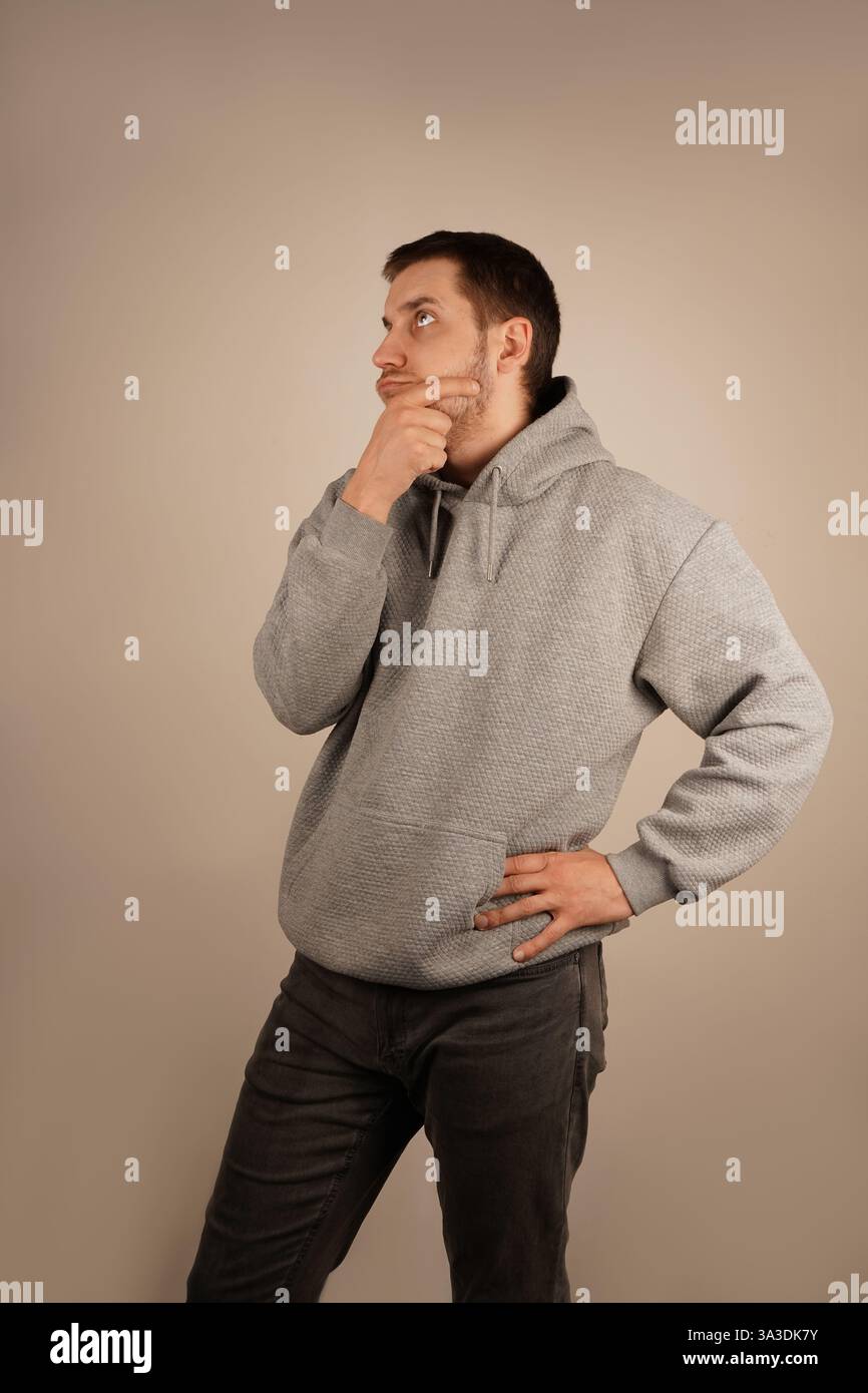 With his hand on his chin, the man appears deep in thought. His gaze ...