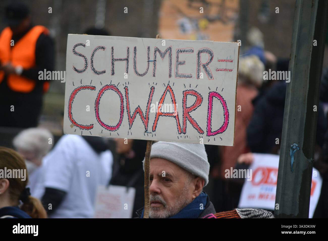 Anti-Chuck Schumer signs at in a Stop the Cuts rally against DOGE cuts ...