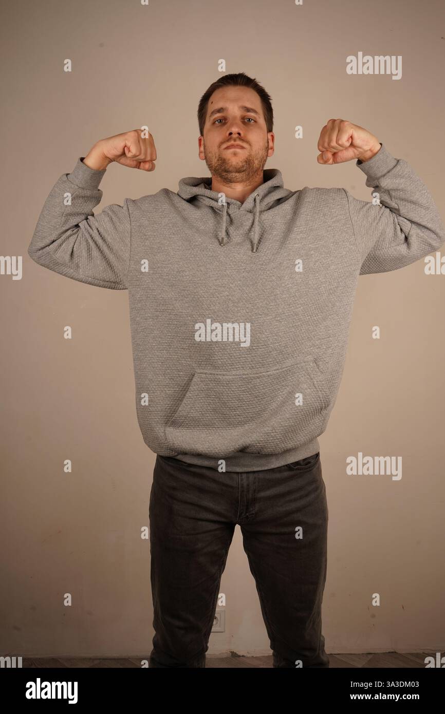 His pose emphasizes his physical strength and confidence. This gesture ...