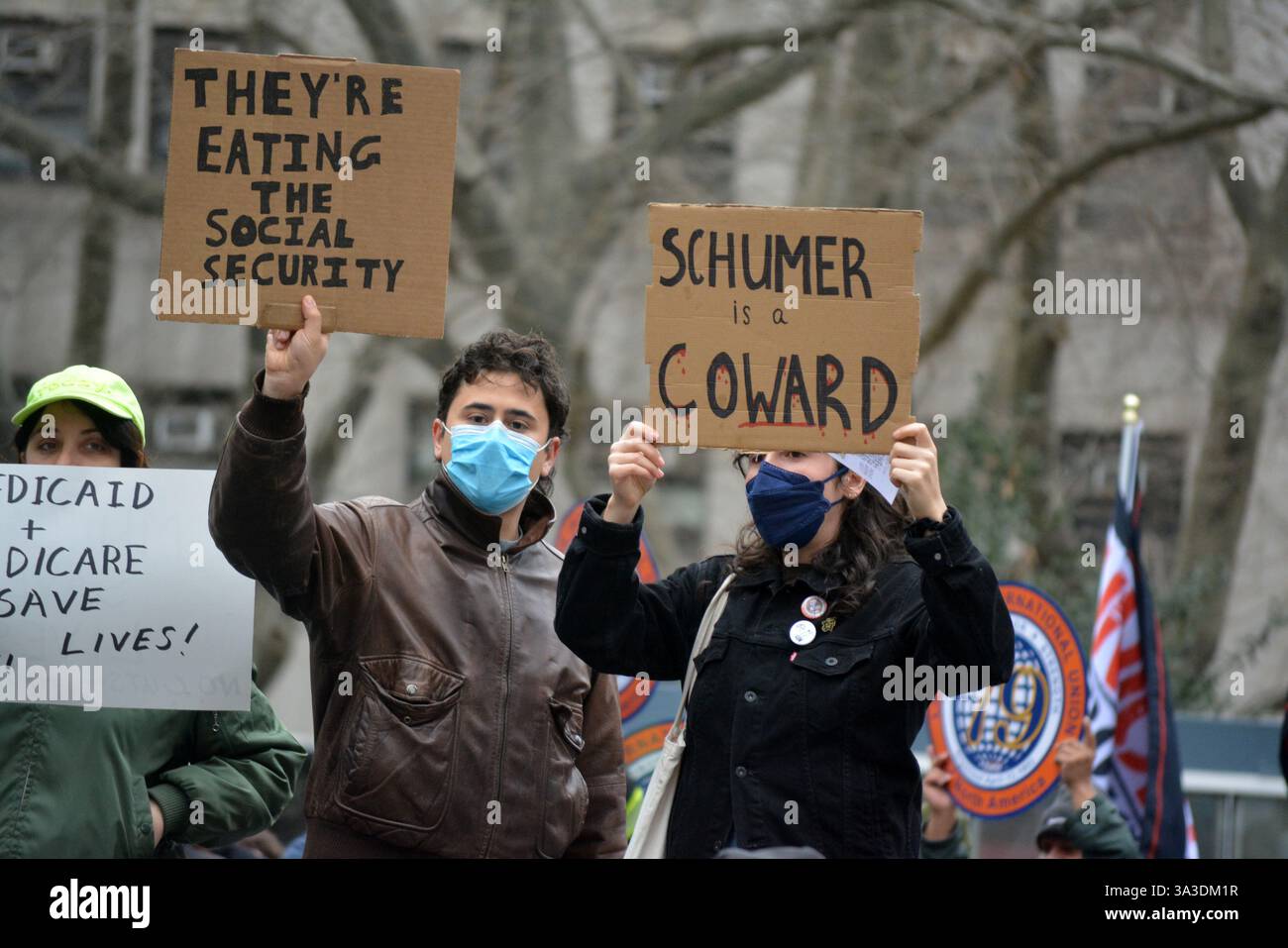Anti-Chuck Schumer signs at in a Stop the Cuts rally against DOGE cuts ...