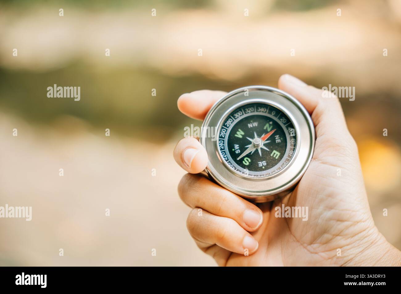 Traveler holds a compass in a park finding her way amidst confusion ...