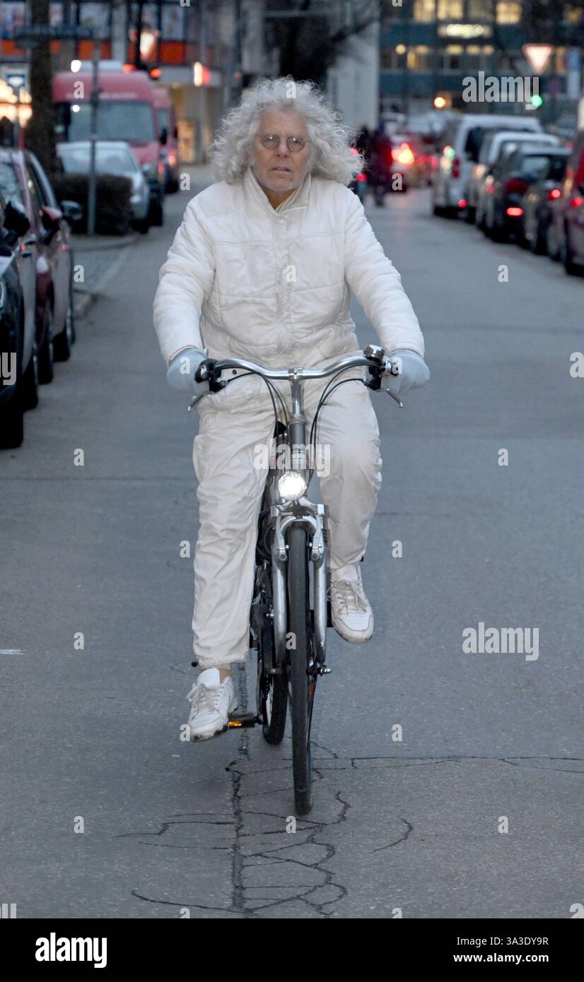 Munich, Germany. 14th Mar, 2025. Rainer Langhans rides his bike through ...