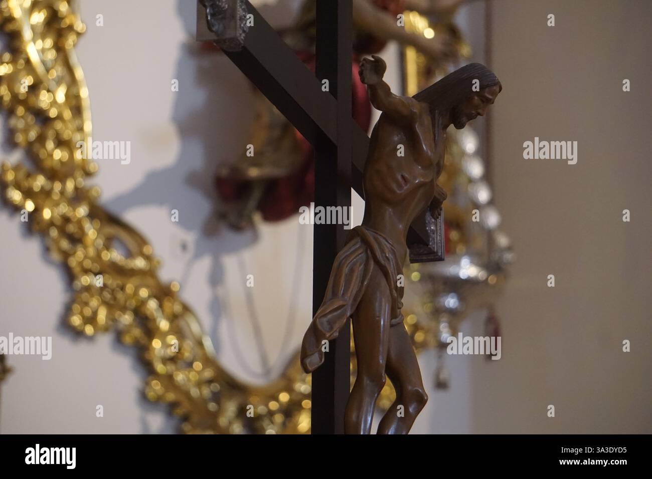 Close up of Jesus Christ on a crucifix on the ornate golden altar of a ...