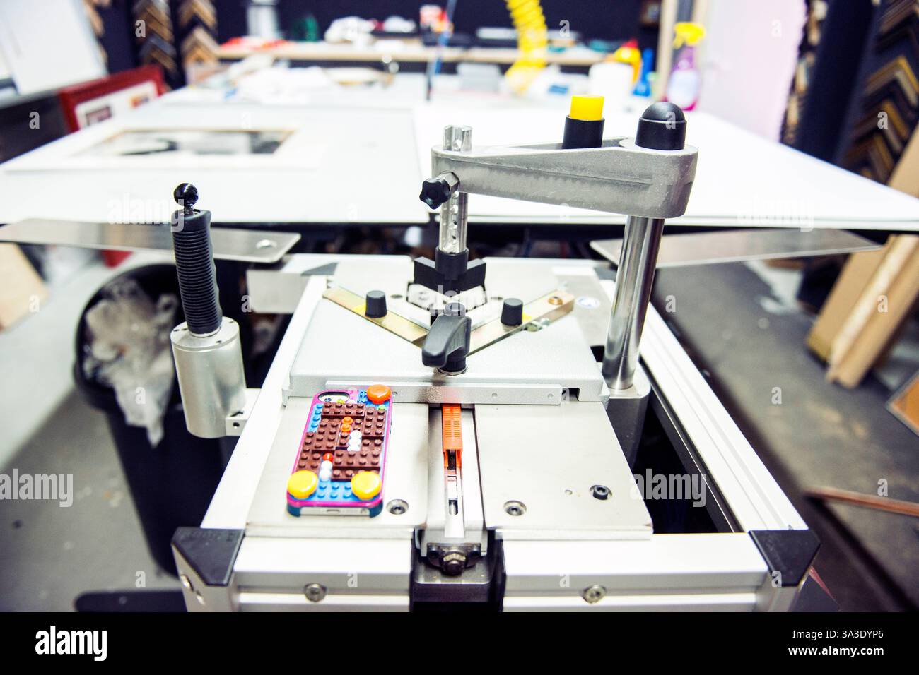 Framing machine and workbench inside workshop Goirle, Netherlands. Pictureframe corner machine ...