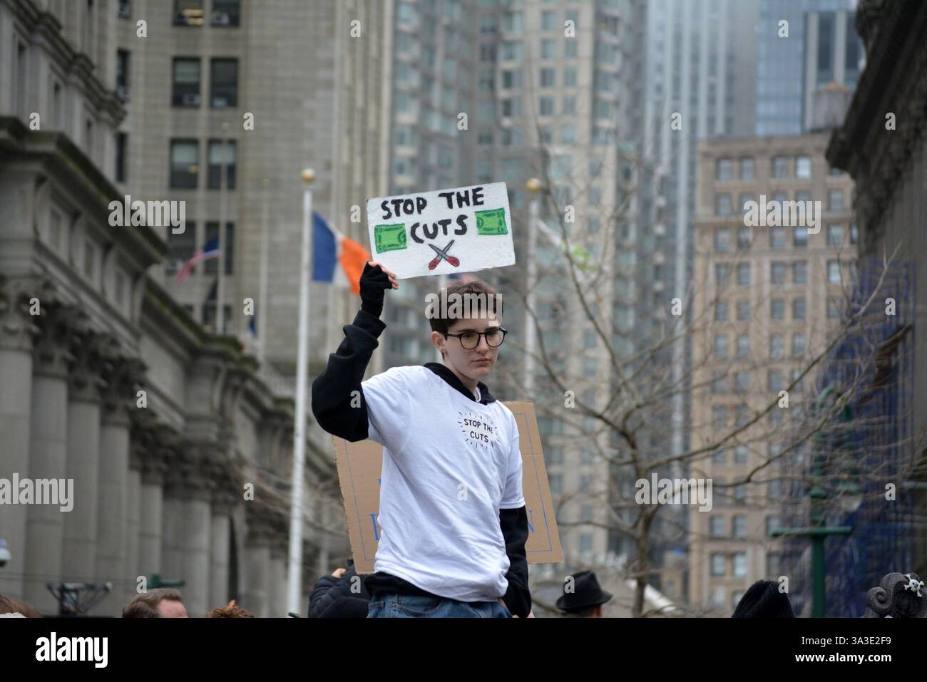 People with signs at a Stop the Cuts rally against DOGE cuts to federal ...