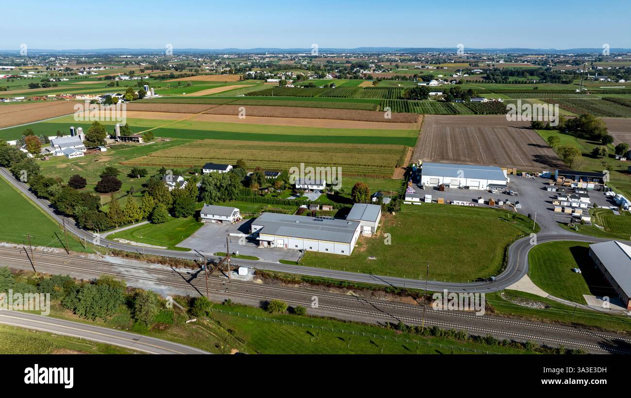 Expansive farmland showcases a variety of crops and structures in a ...