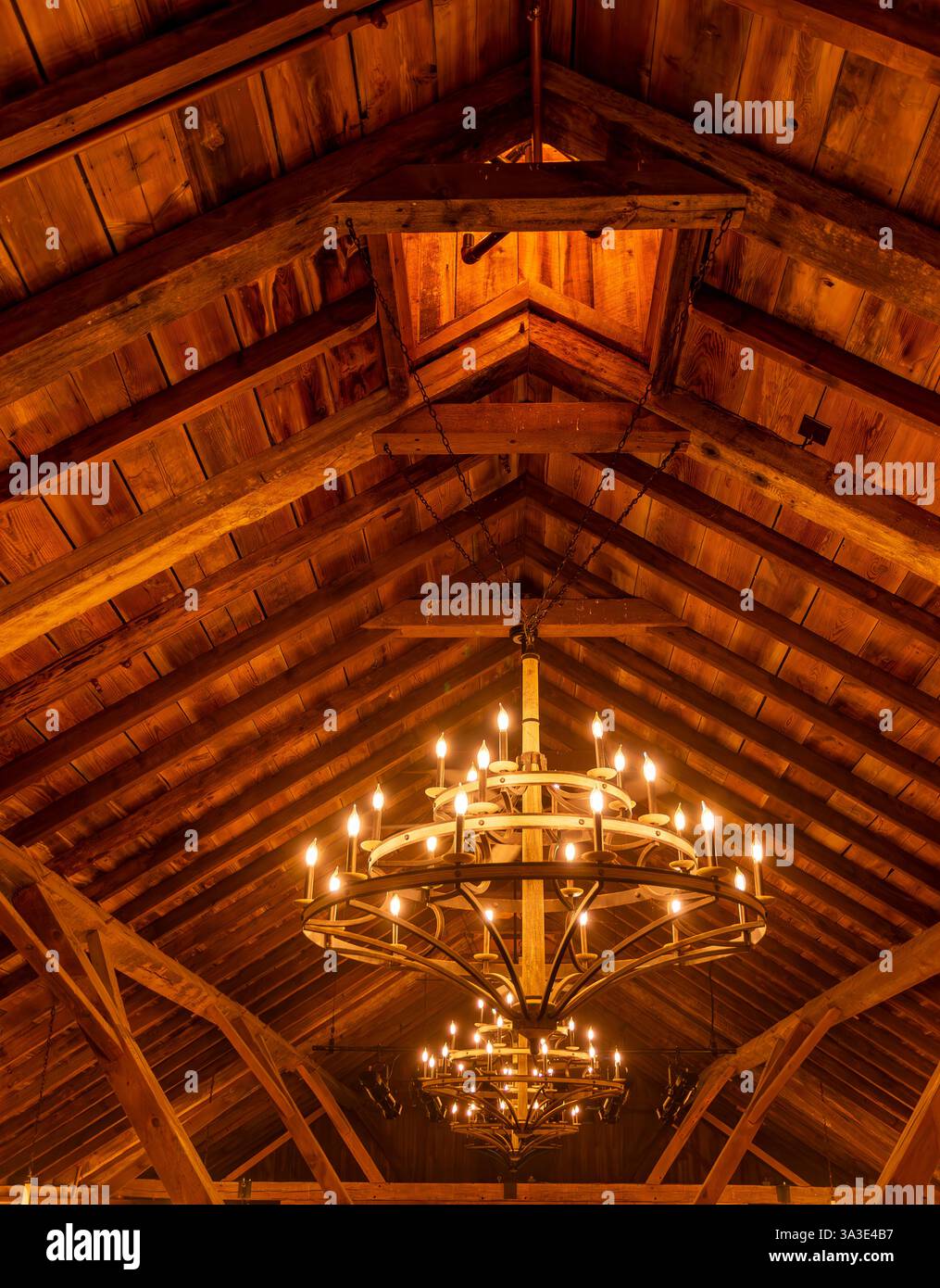 The warm interior of a rustic barn features exposed wooden beams and ...
