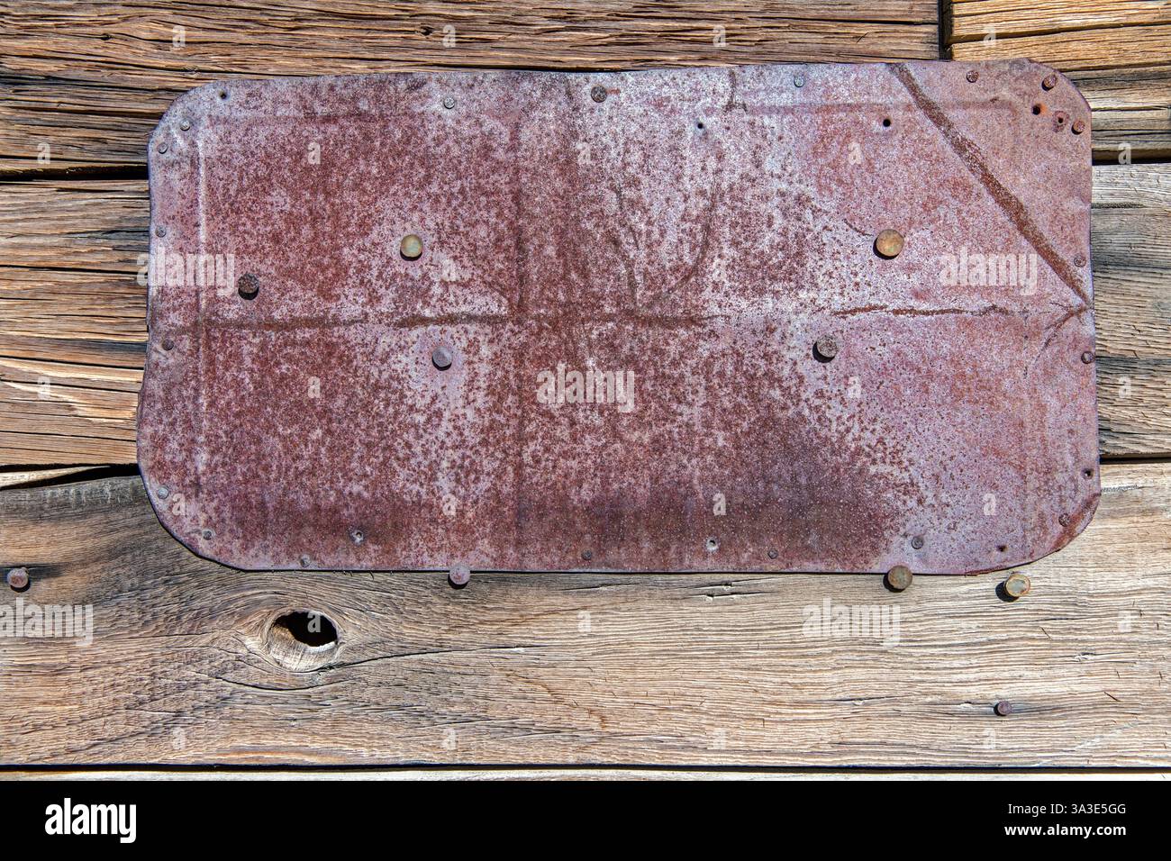 A rusty metal plate is nailed to the exterior wall of a miner's shack ...