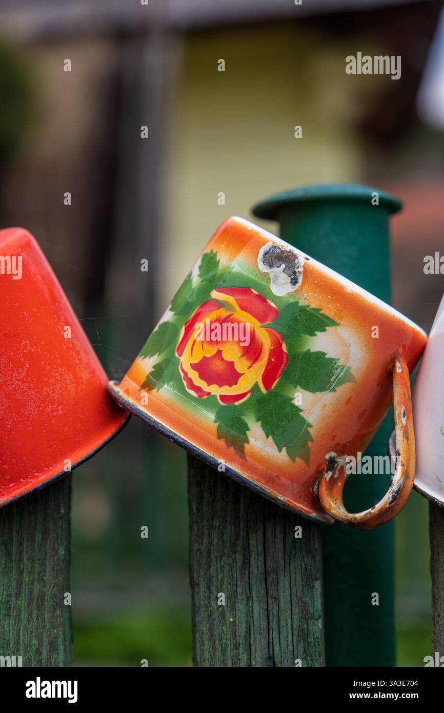 Metal mugs on a wooden fence in the traditional village of Vlkolínec ...