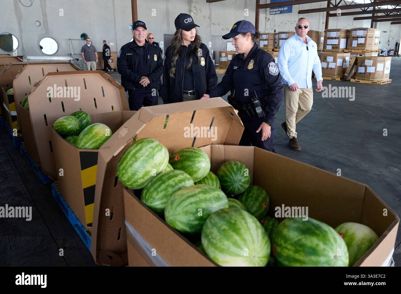 Homeland Security Secretary Kristi Noem, center, speaks with acting ...