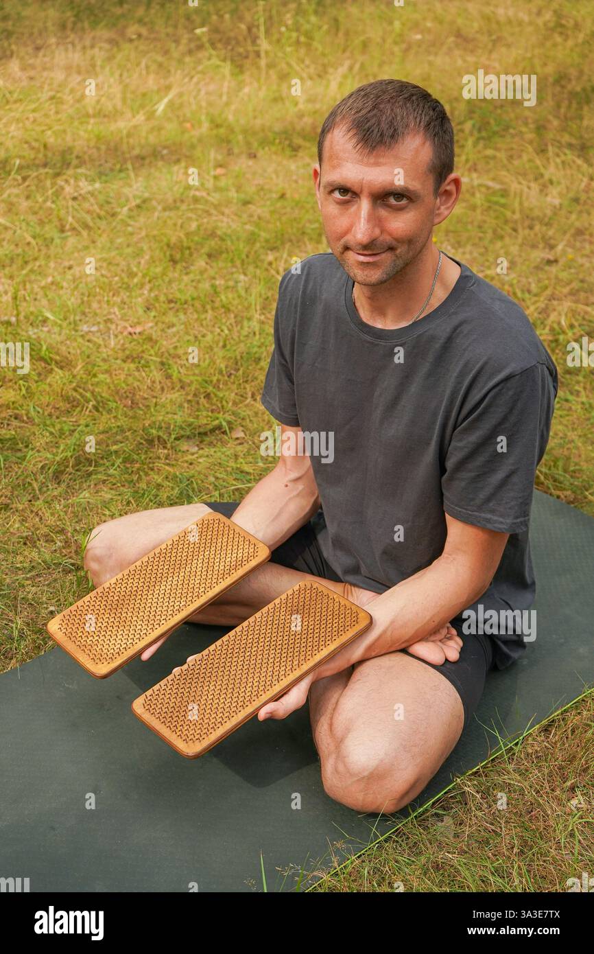 A man practicing meditation in a serene forest, sitting cross-legged on ...