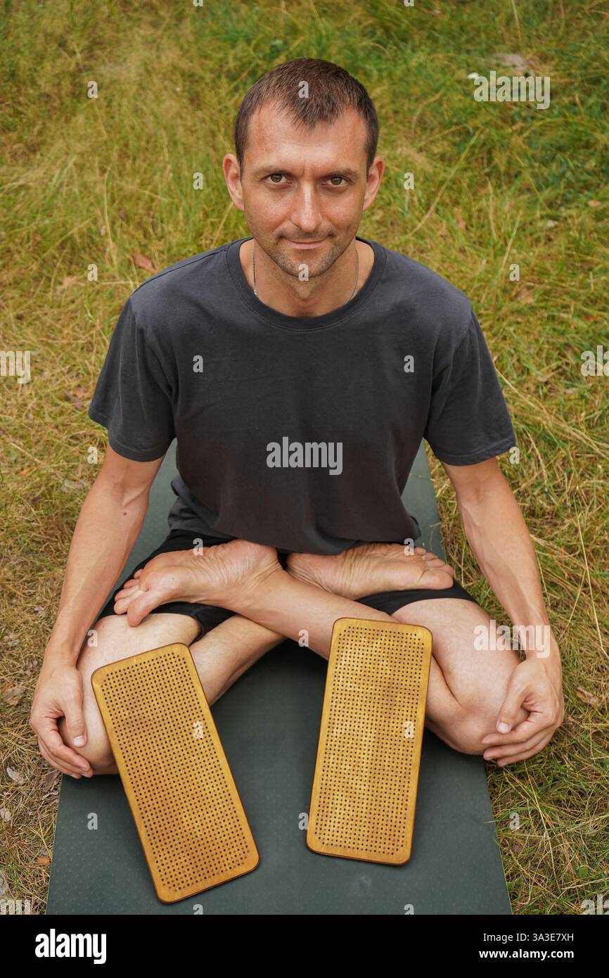 A man practicing meditation in a serene forest, sitting cross-legged on ...