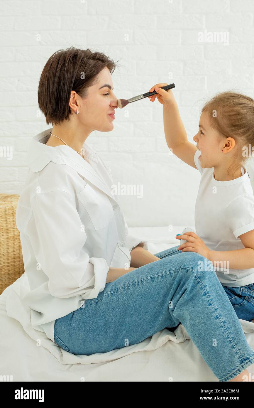 Mother and daughter playfully spending time together on the couch ...
