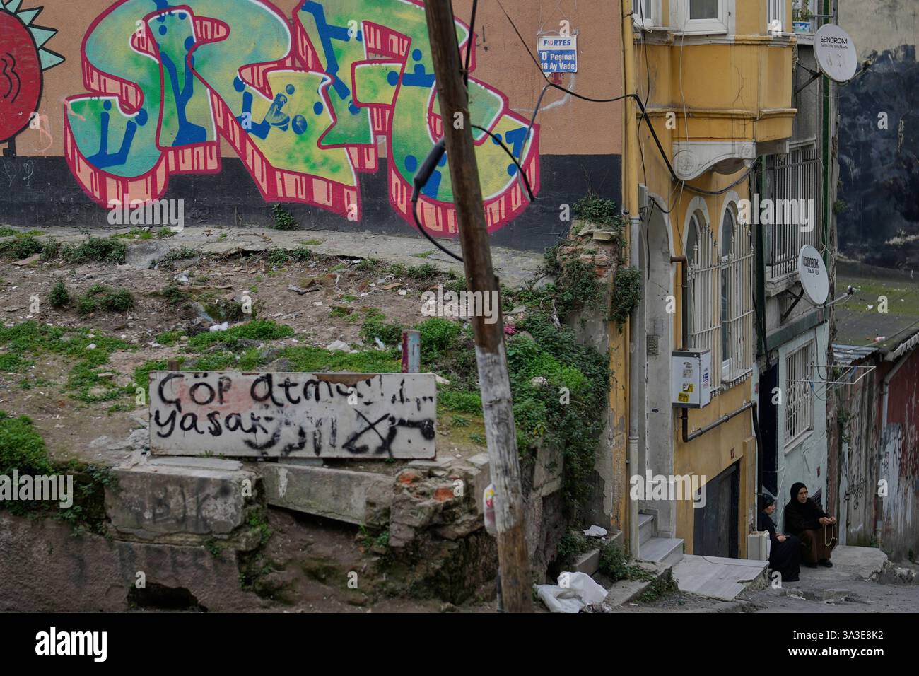 Women sit outside their home in a poor neighborhood in Istanbul, Turkey ...
