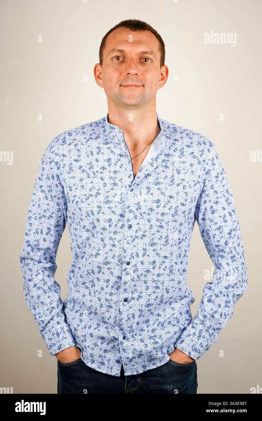 A stylish young man poses in a light blue shirt, exuding sophistication ...