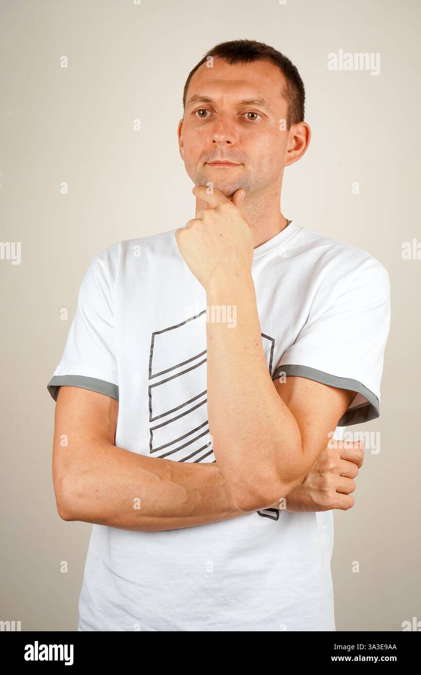 His relaxed posture conveys a sense of ease. The setting is minimal ...