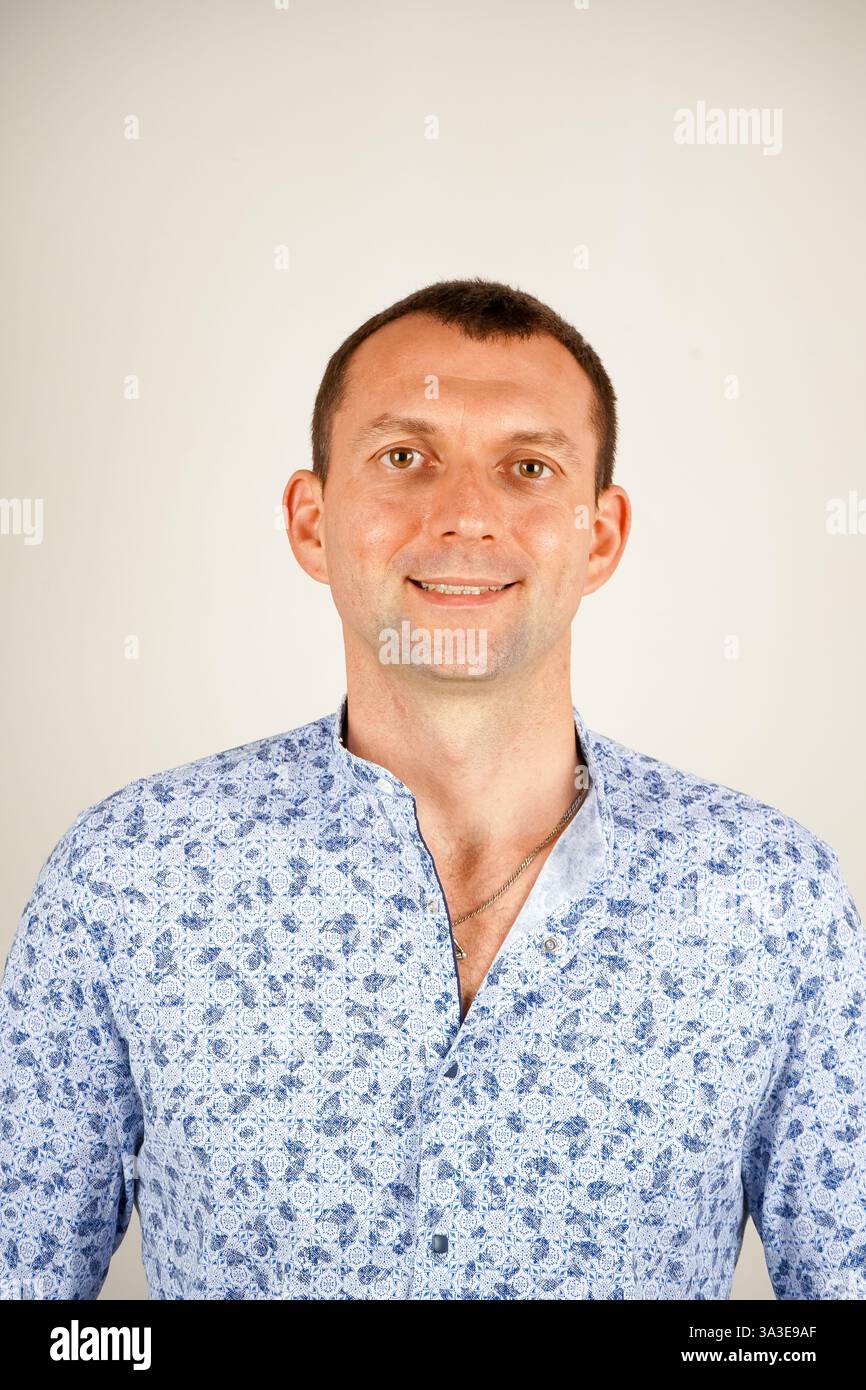 A stylish young man poses in a light blue shirt, exuding sophistication ...