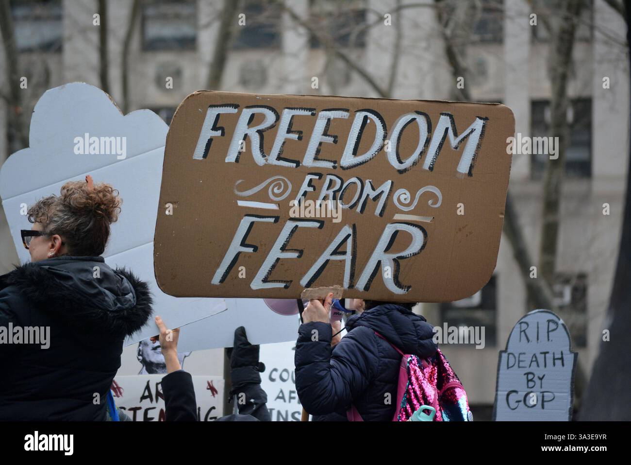 Sign at a Stop the Cuts rally against DOGE cuts to federal funding in ...