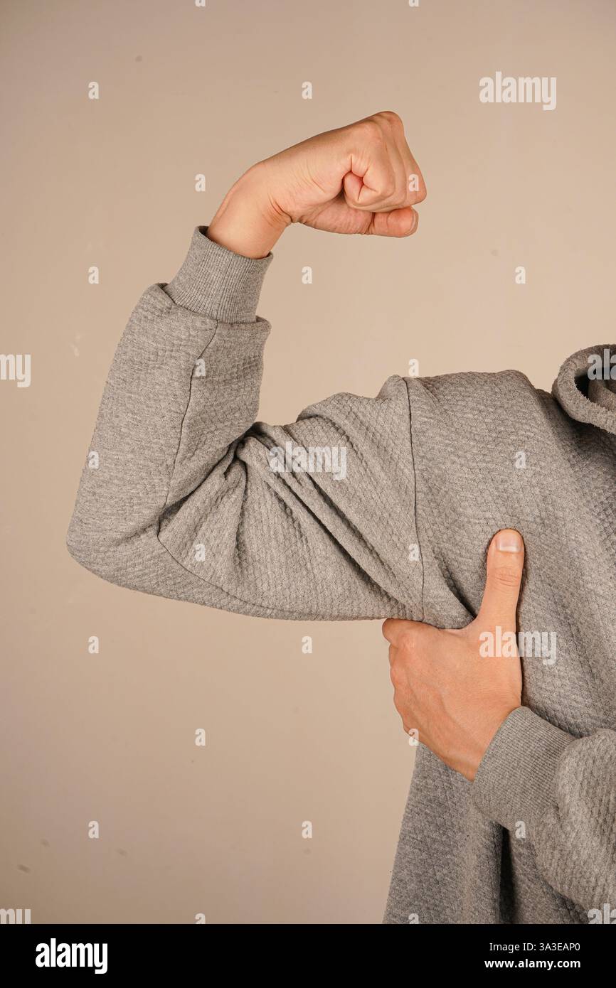 The clean background ensures the focus remains on the gesture. A flexed ...