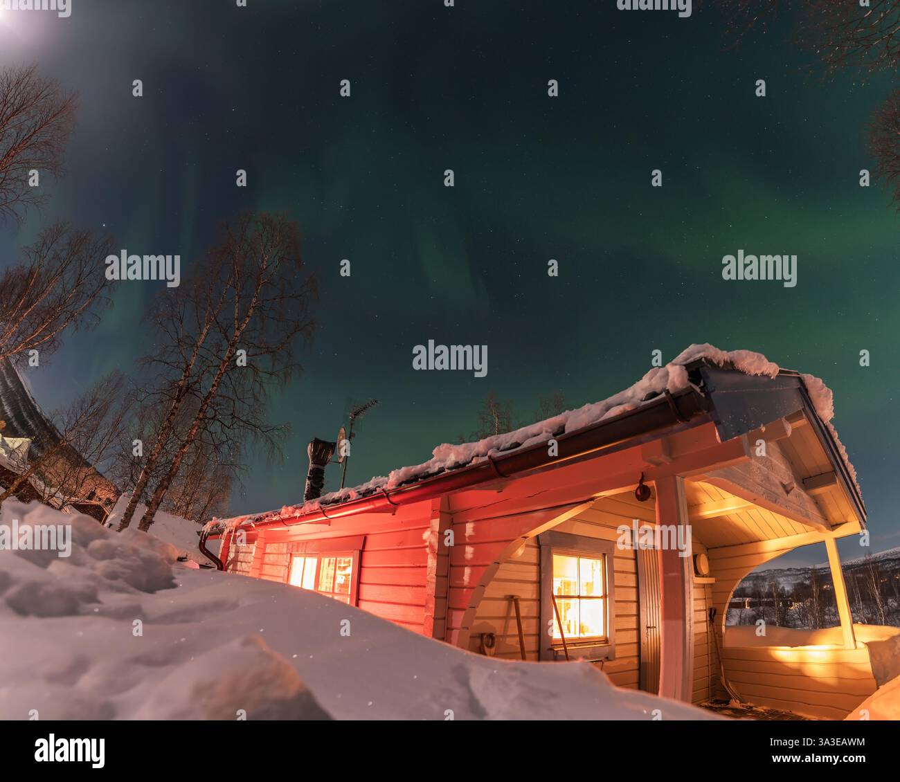 Snow covered cozy wooden cabin glowing warmly under a breathtaking ...