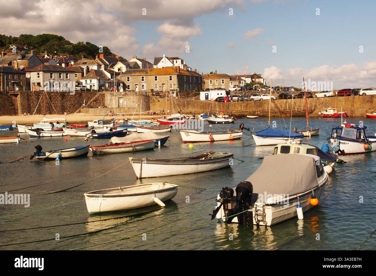 A view across to the narrow harbour entrance at Mousehole with small ...