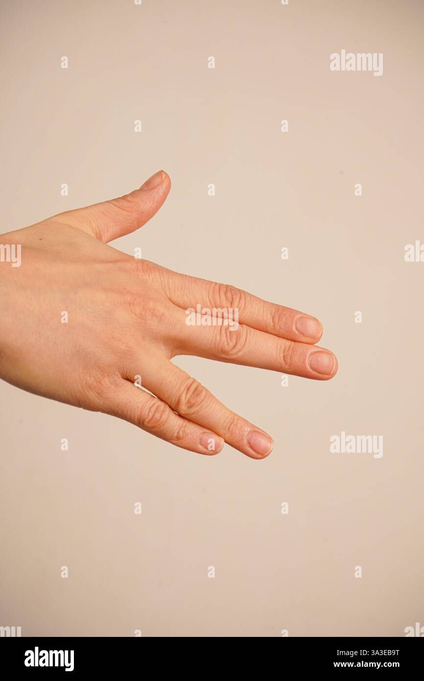 The hand shows two fingers extended and spread. The index and middle ...