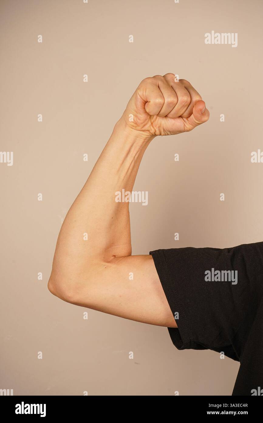 The clean background ensures the focus remains on the gesture. The powerful gesture conveys ...