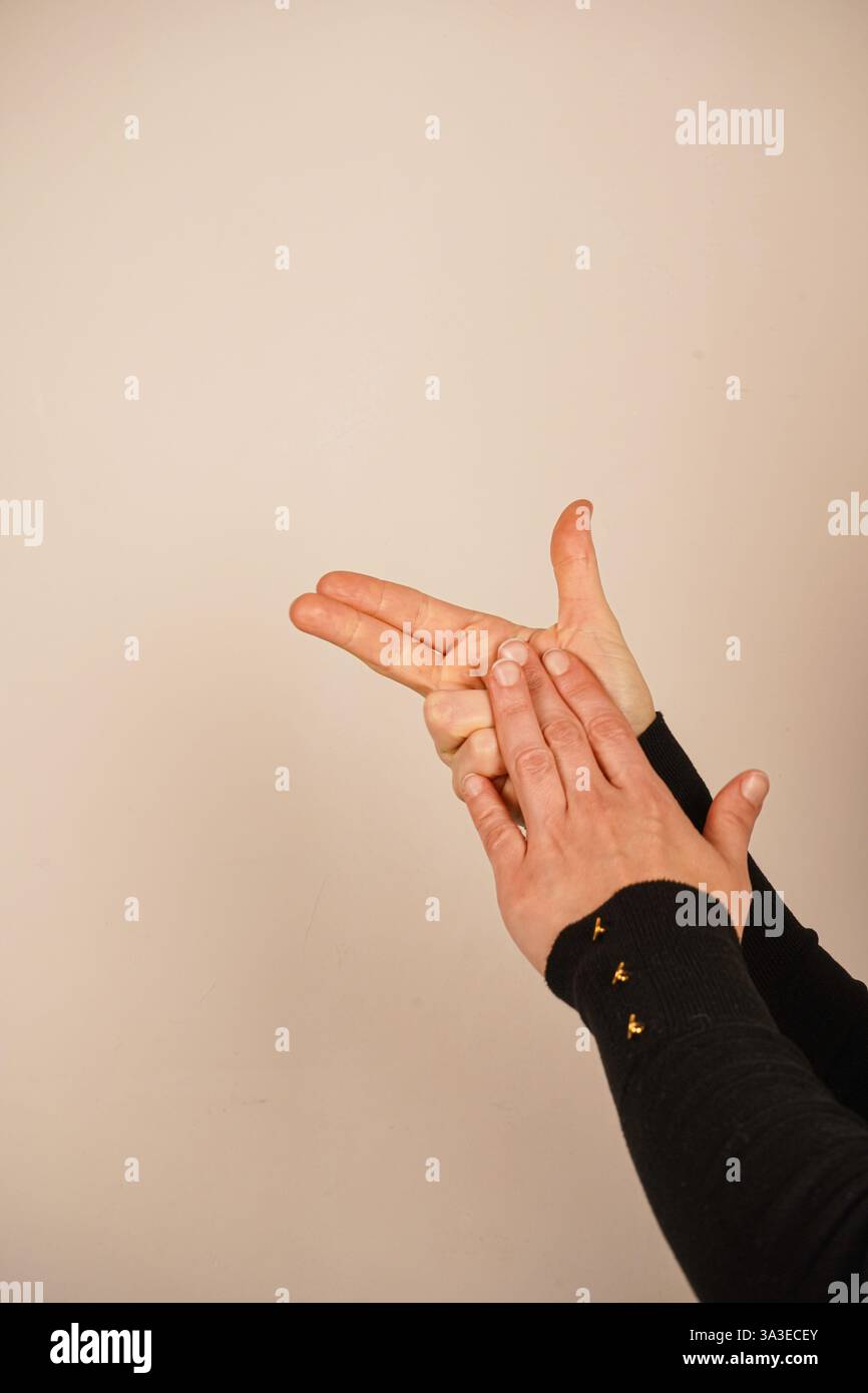 Fingers are arranged to mimic the shape of a gun, creating a playful ...