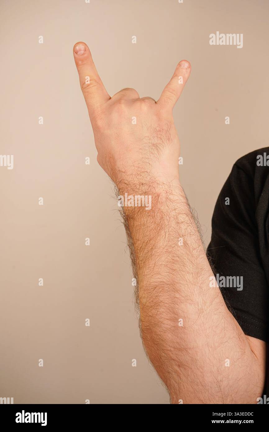 The hand raised in the classic rock and roll gesture symbolizes ...