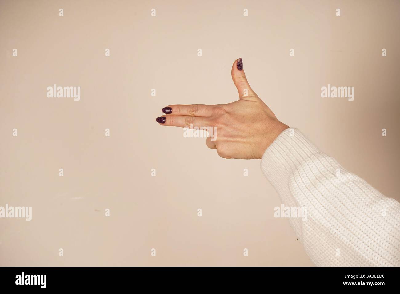 The hand forms a pistol-like shape with extended fingers, symbolizing ...
