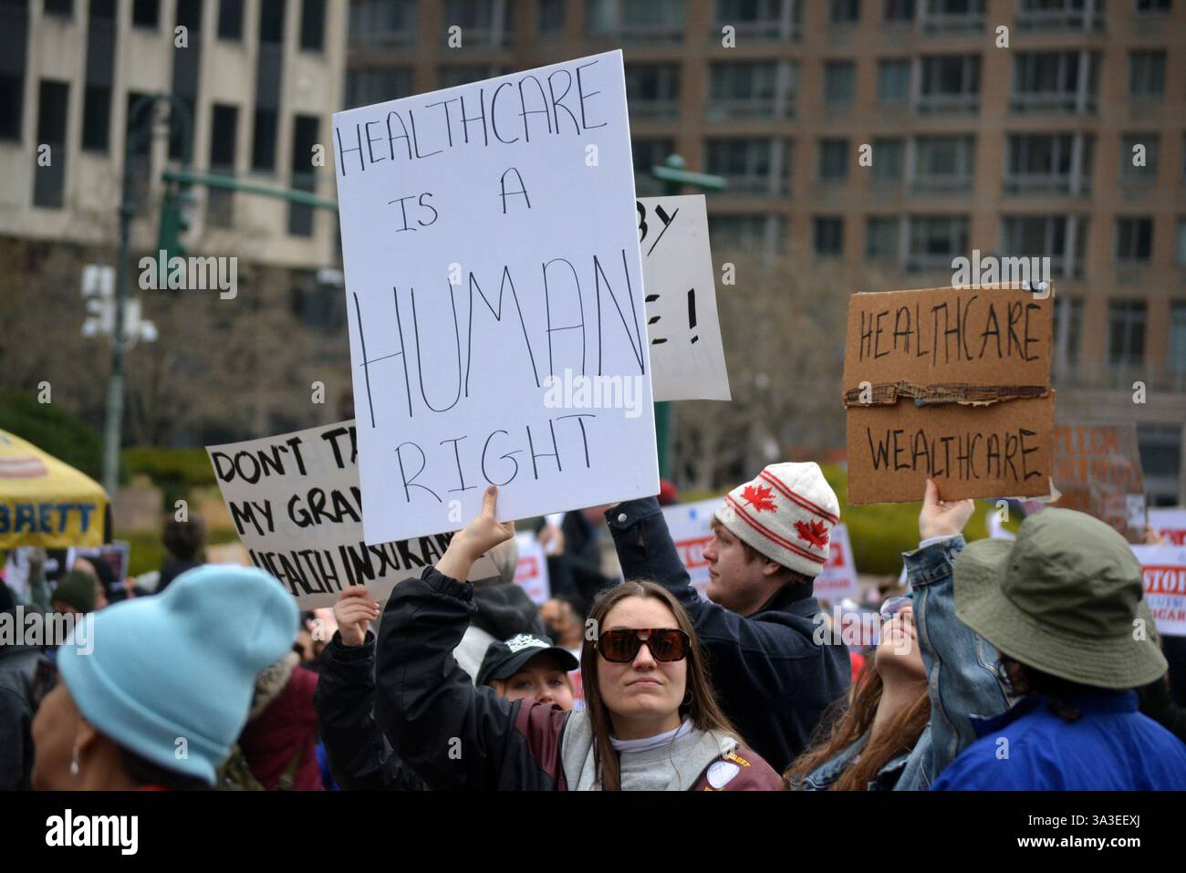 People with signs at a Stop the Cuts rally against DOGE cuts to federal ...