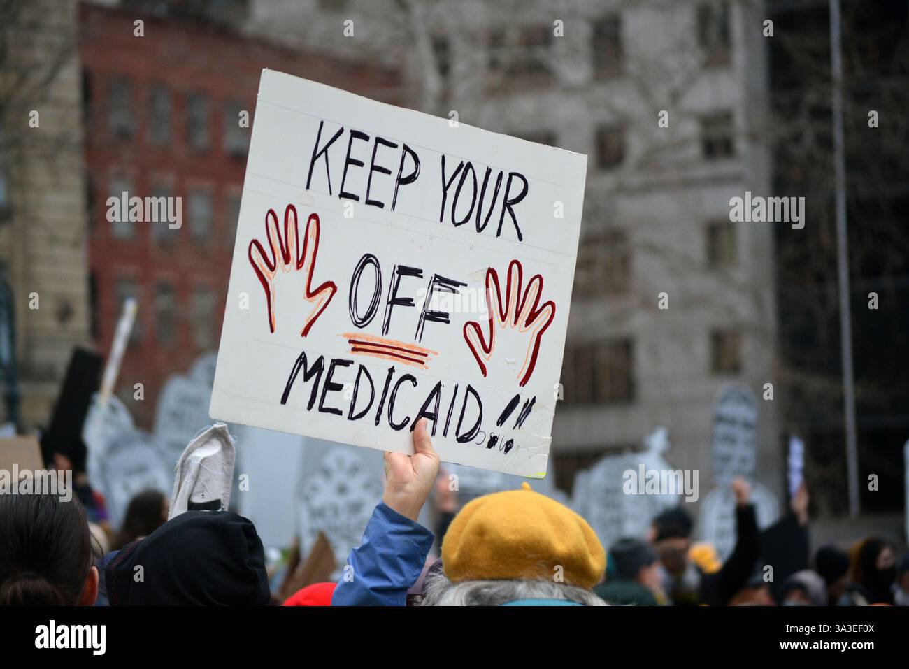People with signs at a Stop the Cuts rally against DOGE cuts to federal ...