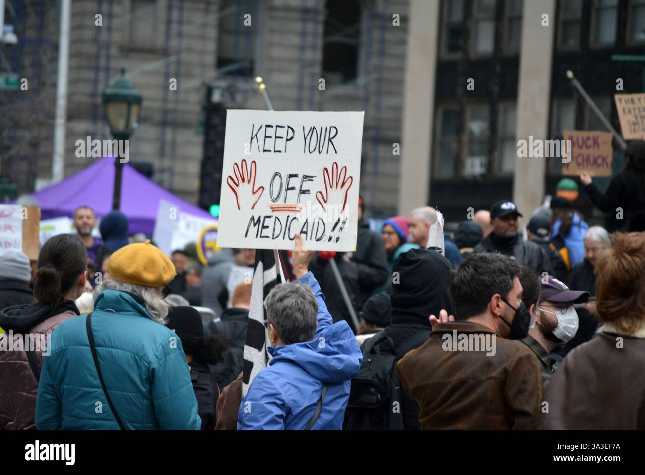 People with signs at a Stop the Cuts rally against DOGE cuts to federal ...