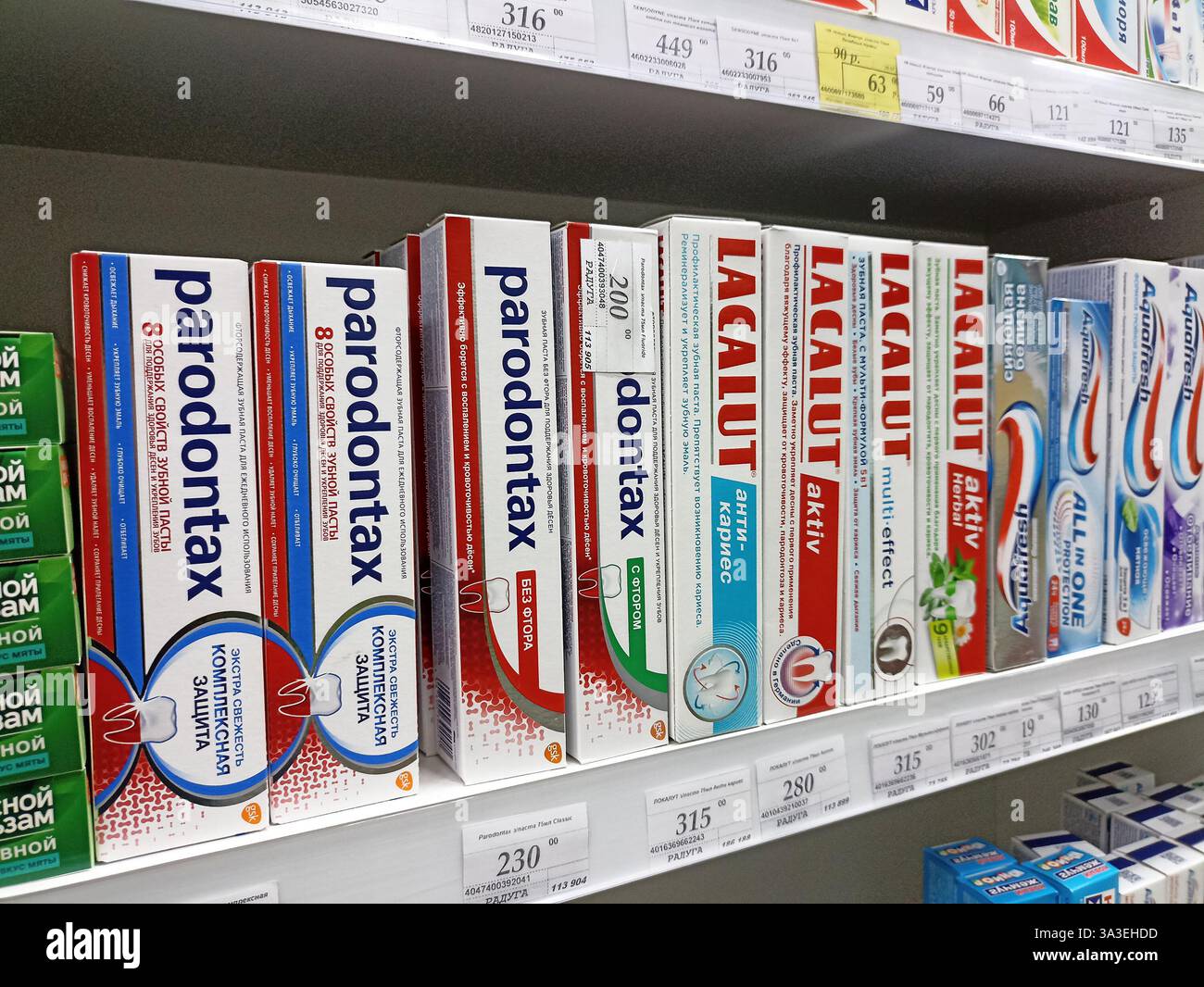 Variety of toothpaste brands on store shelf with prices in russian ...