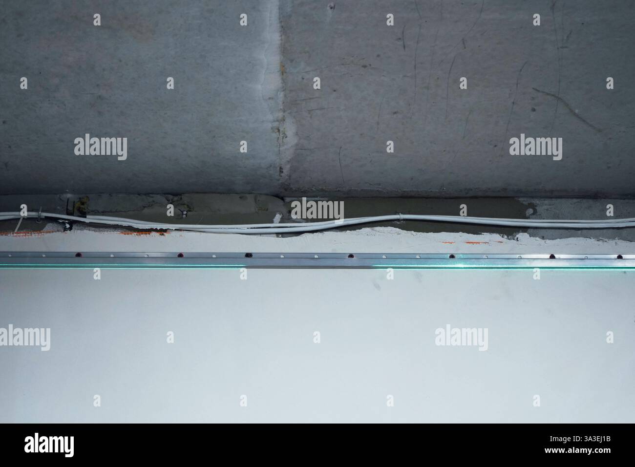 A green laser level surrounded by walls creates clear horizontal lines ...