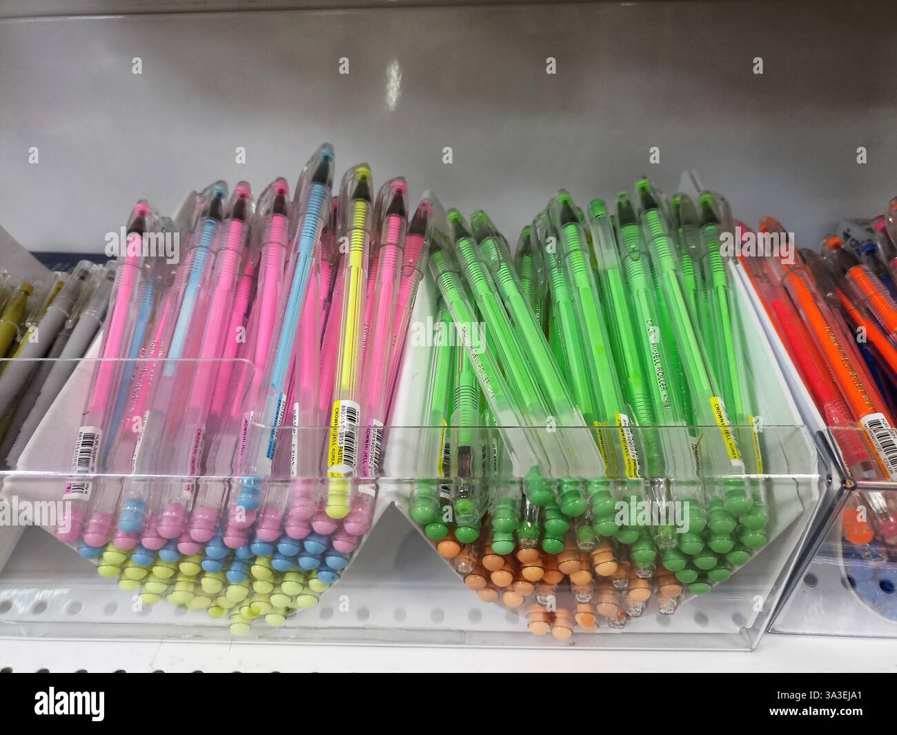 Colorful pens organized in transparent display bins on store shelf ...