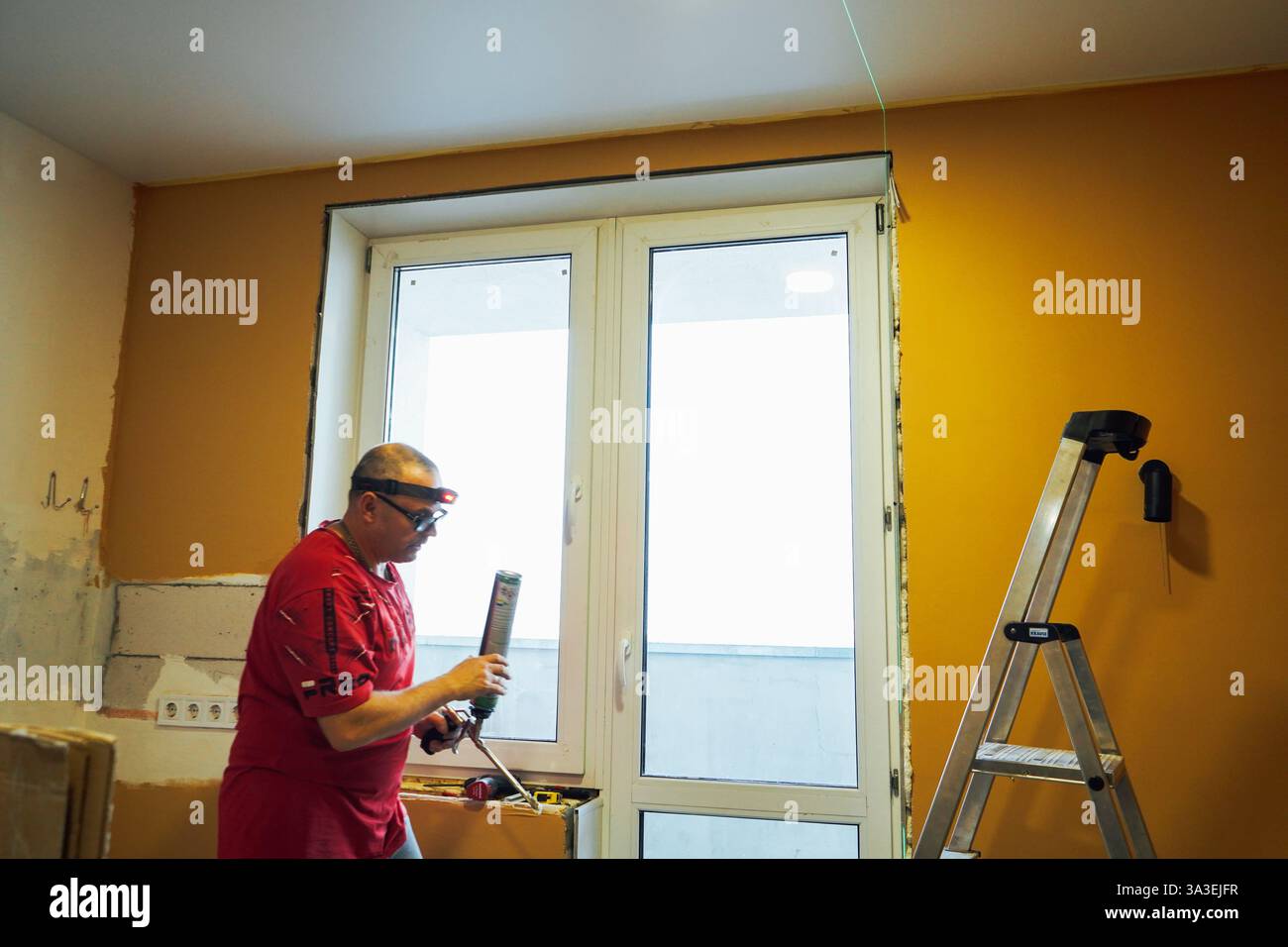 Process installation of window slopes. Using mounting foam. On a peach ...