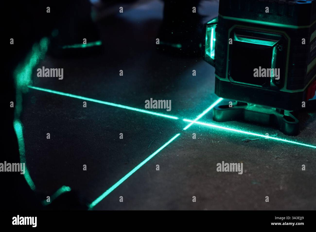 On an unsanded floor, two bright green laser lines smoothly align ...