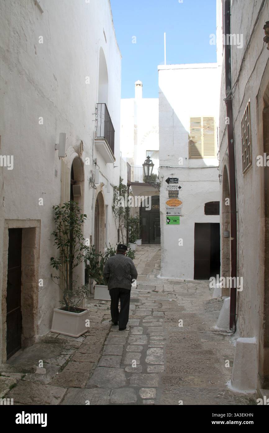 Local man walking on an alleyway in the historical center of Ostuni ...