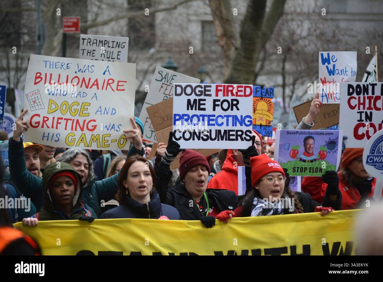 People with signs at a Stop the Cuts rally against DOGE cuts to federal ...