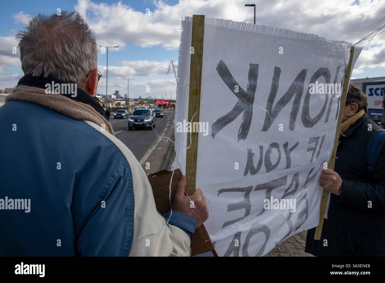 London, UK. 15th Mar, 2025. Two activists hold a banner during the ...