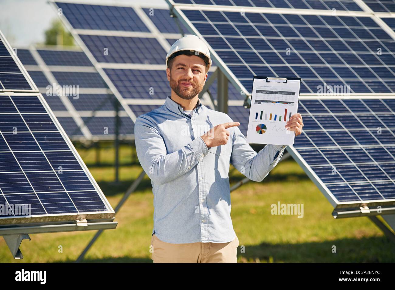 Pointing to the notepad with diagrams and graphs. Engineer with ...