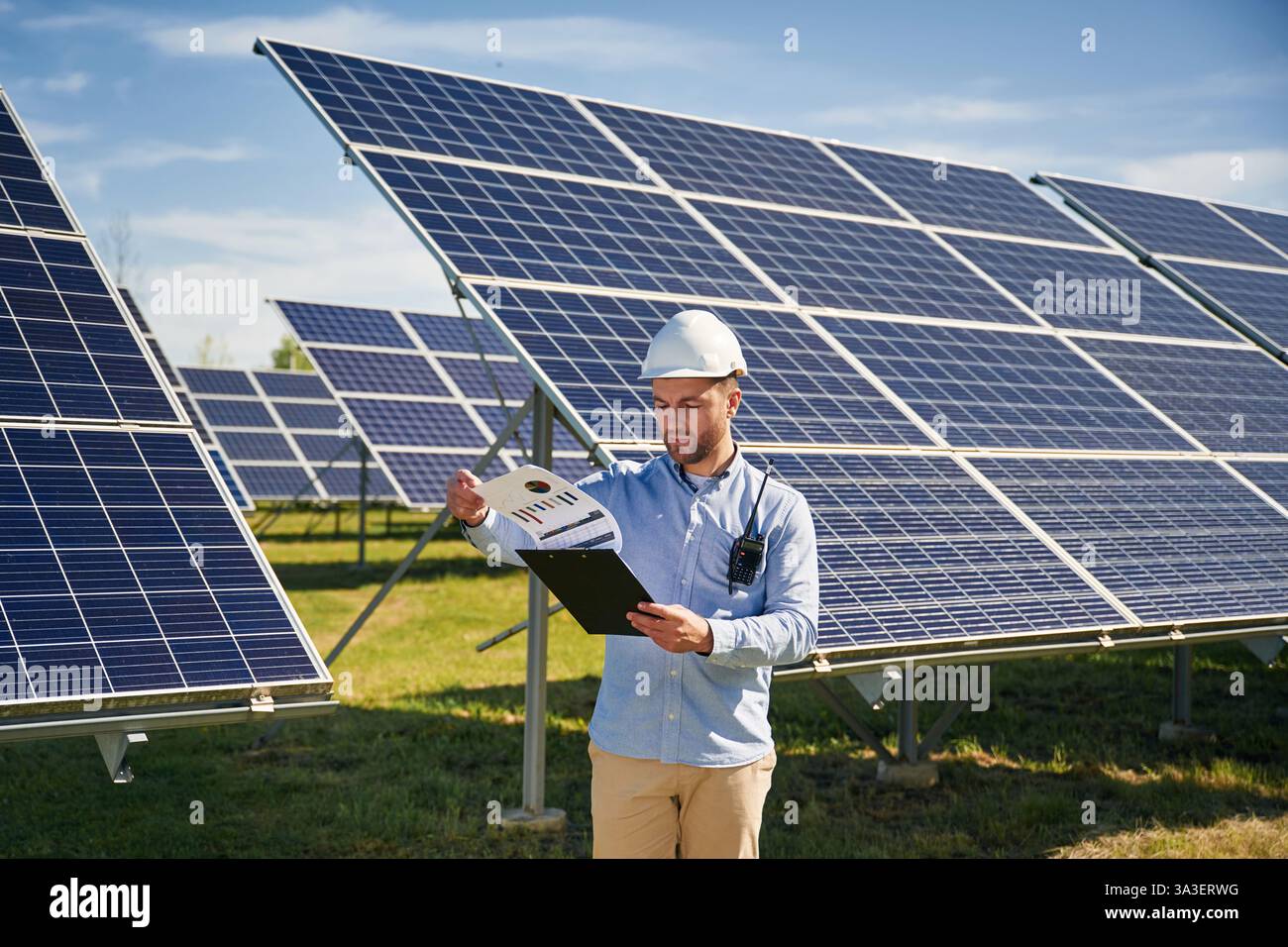 Sunny daytime. Engineer with photovoltaic solar panels outdoors Stock Photo - Alamy