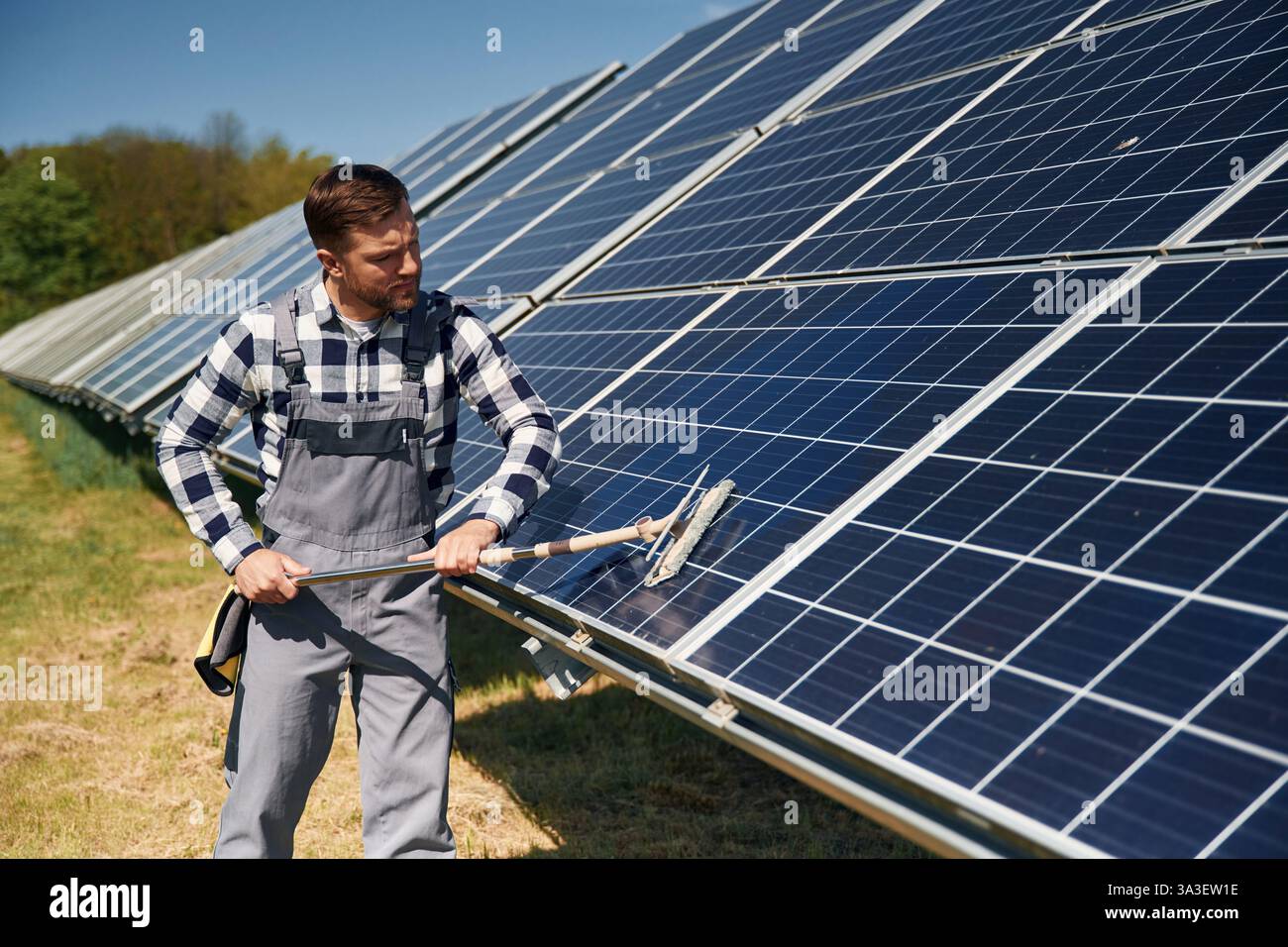 Mop in hands. Cleans the surface. Engineer with photovoltaic solar ...
