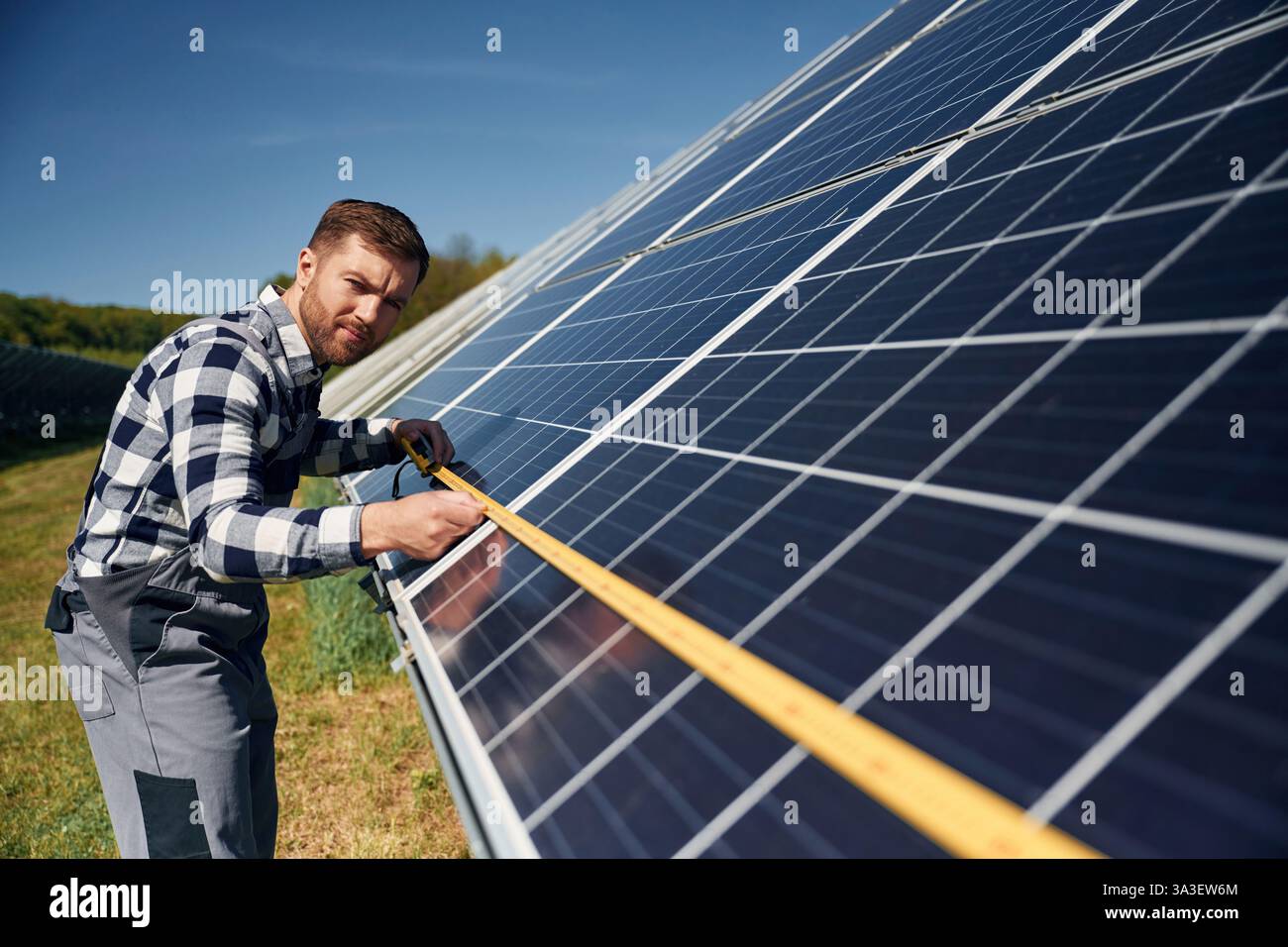 Measuring the width by tape. Engineer with photovoltaic solar panels ...