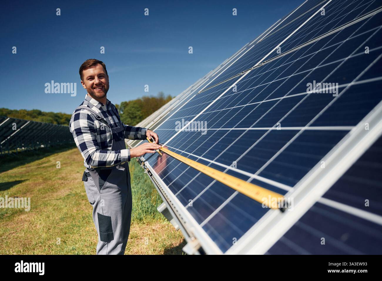 Measuring the width by tape. Engineer with photovoltaic solar panels ...