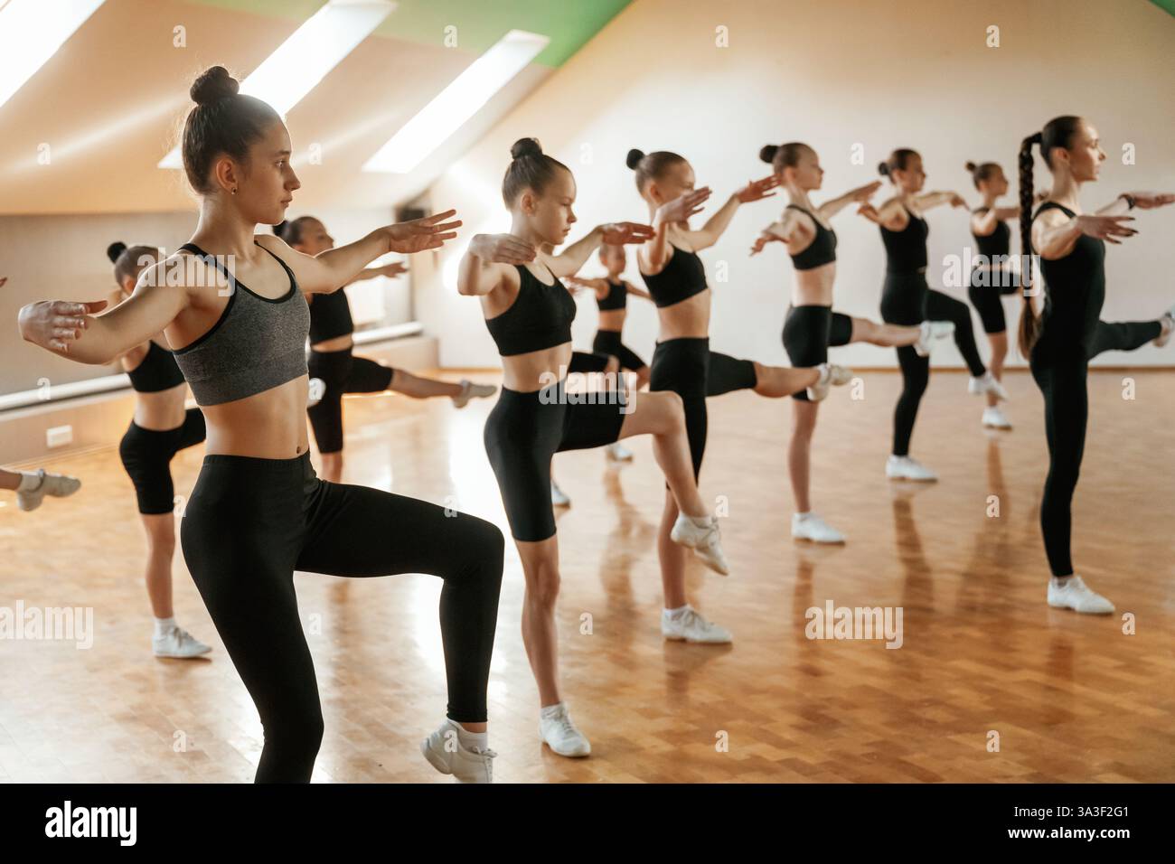Active training. Group of female kids practicing athletic exercises ...