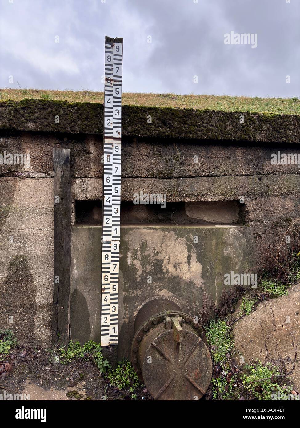 A hydrometric scale is fixed to a concrete surface, likely part of a ...