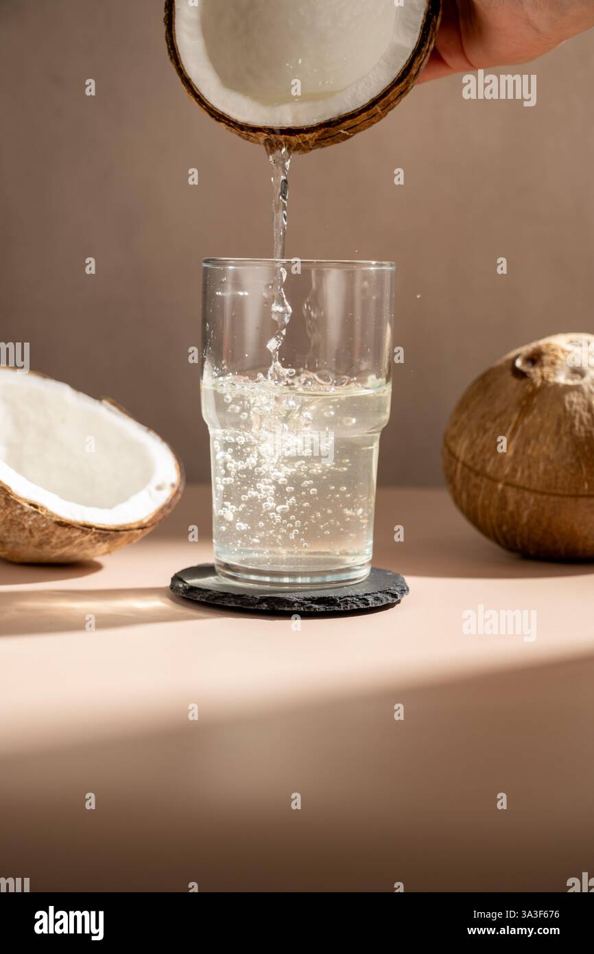 Fresh coconut water in a glass with straw Stock Photo - Alamy