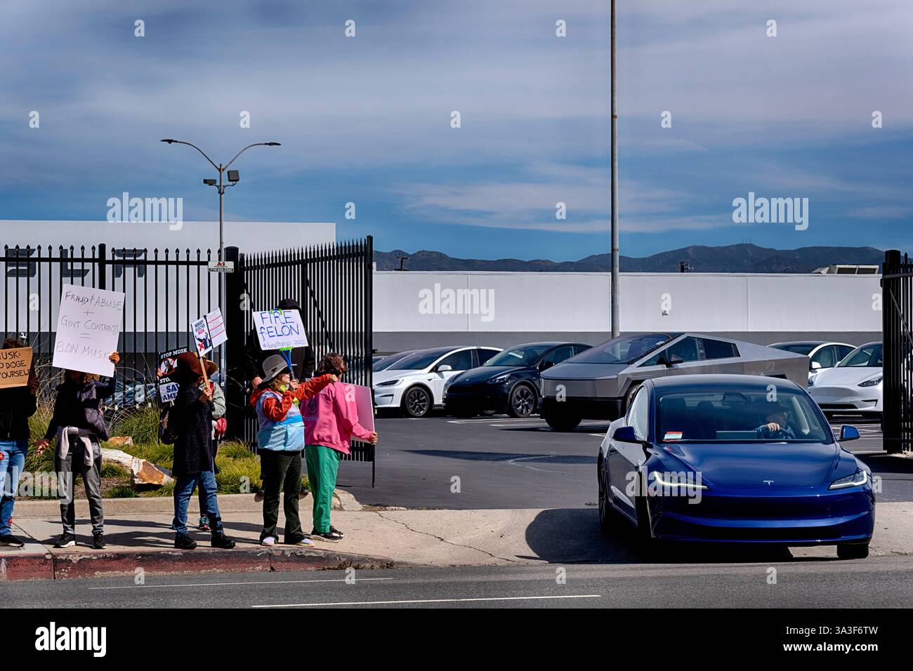 Protesters carrying signs and chant slogans protesting Elon Musk and ...